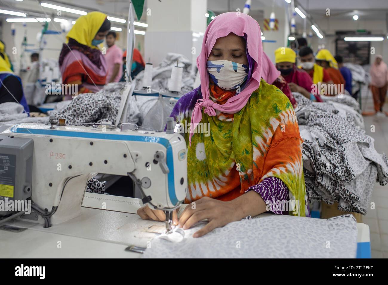 Garment workers work in a sewing section at the Surma Garments Limited ...