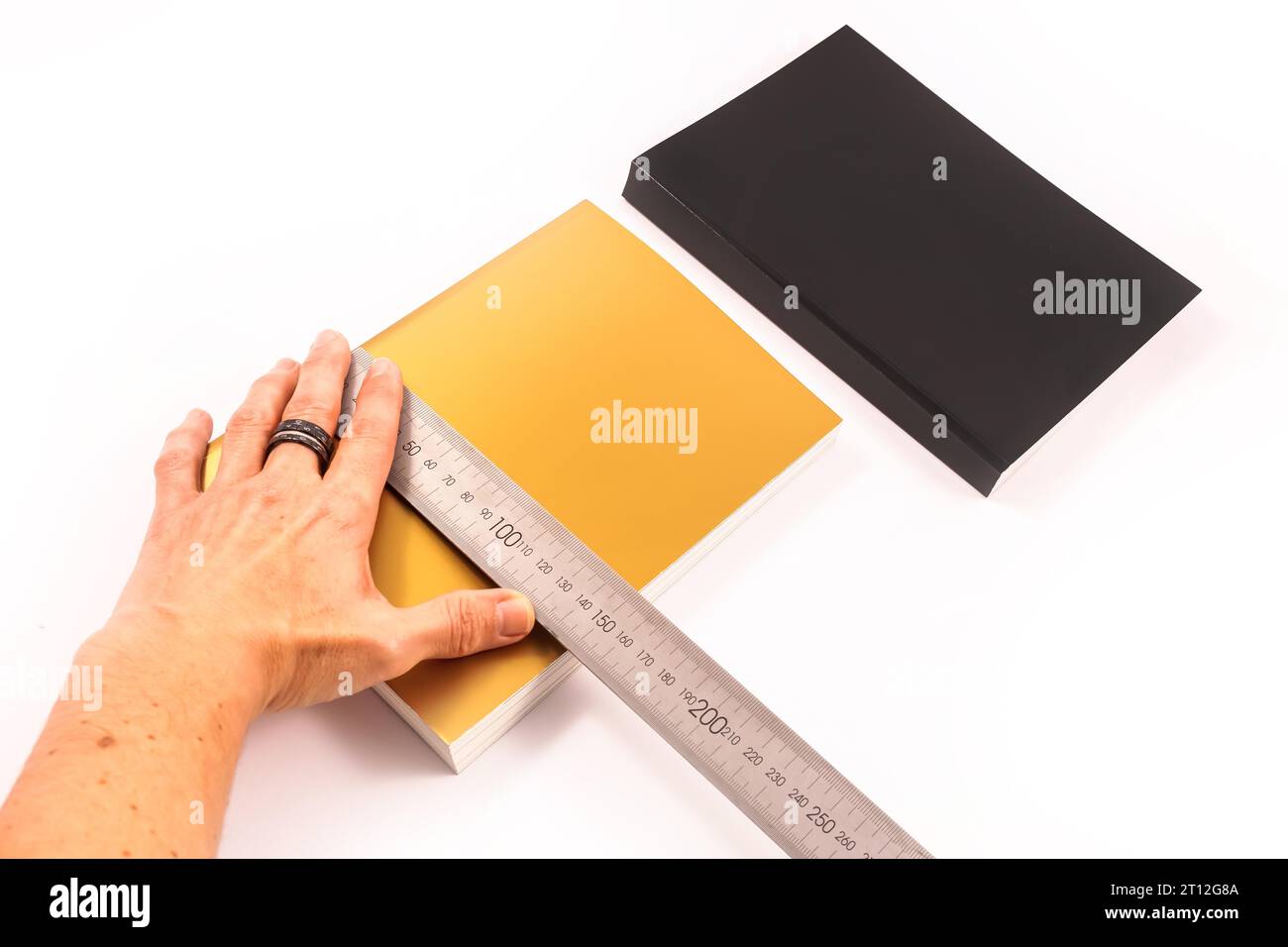 Detail of a hand measuring a book, binding in the graphic sector ...