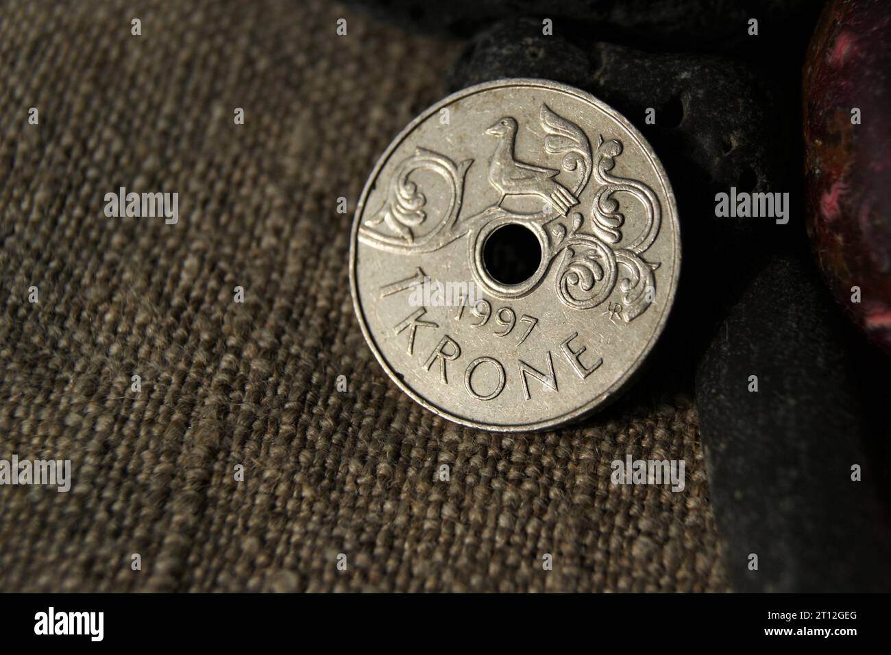 1 Krone Harald V. Norwegian coin and stones on natural linen fabric ...