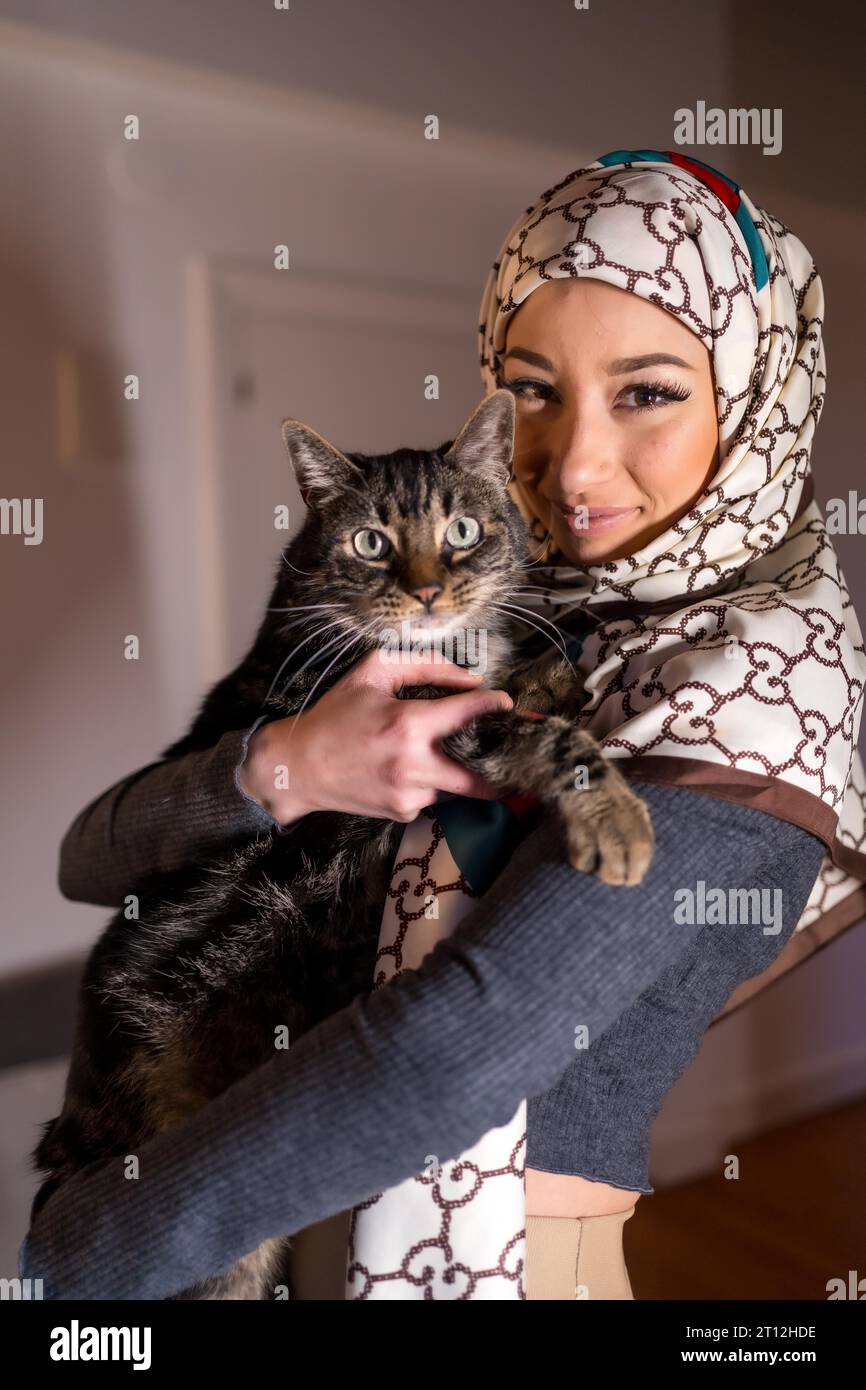 Portrait of a white veiled Arab girl with a lovely cat at home Stock ...