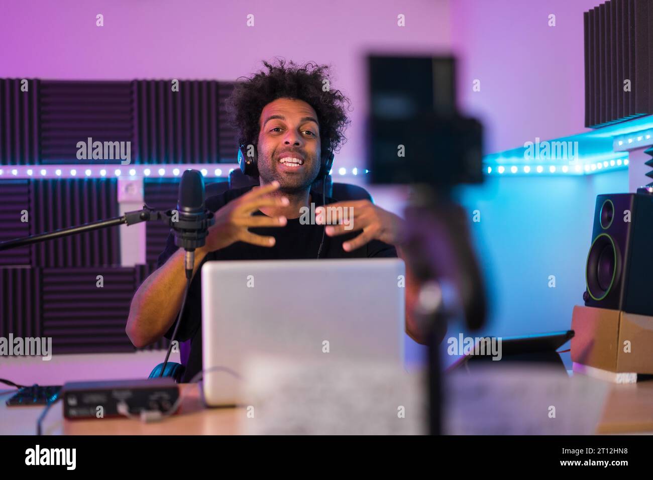 Frontal view of a vlogger recording a video tutorial in a music studio ...