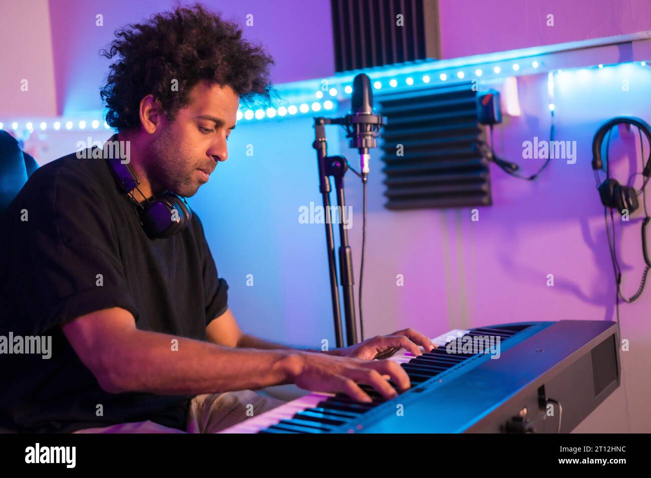 Producer playing a piano in studio creating a new album Stock Photo - Alamy