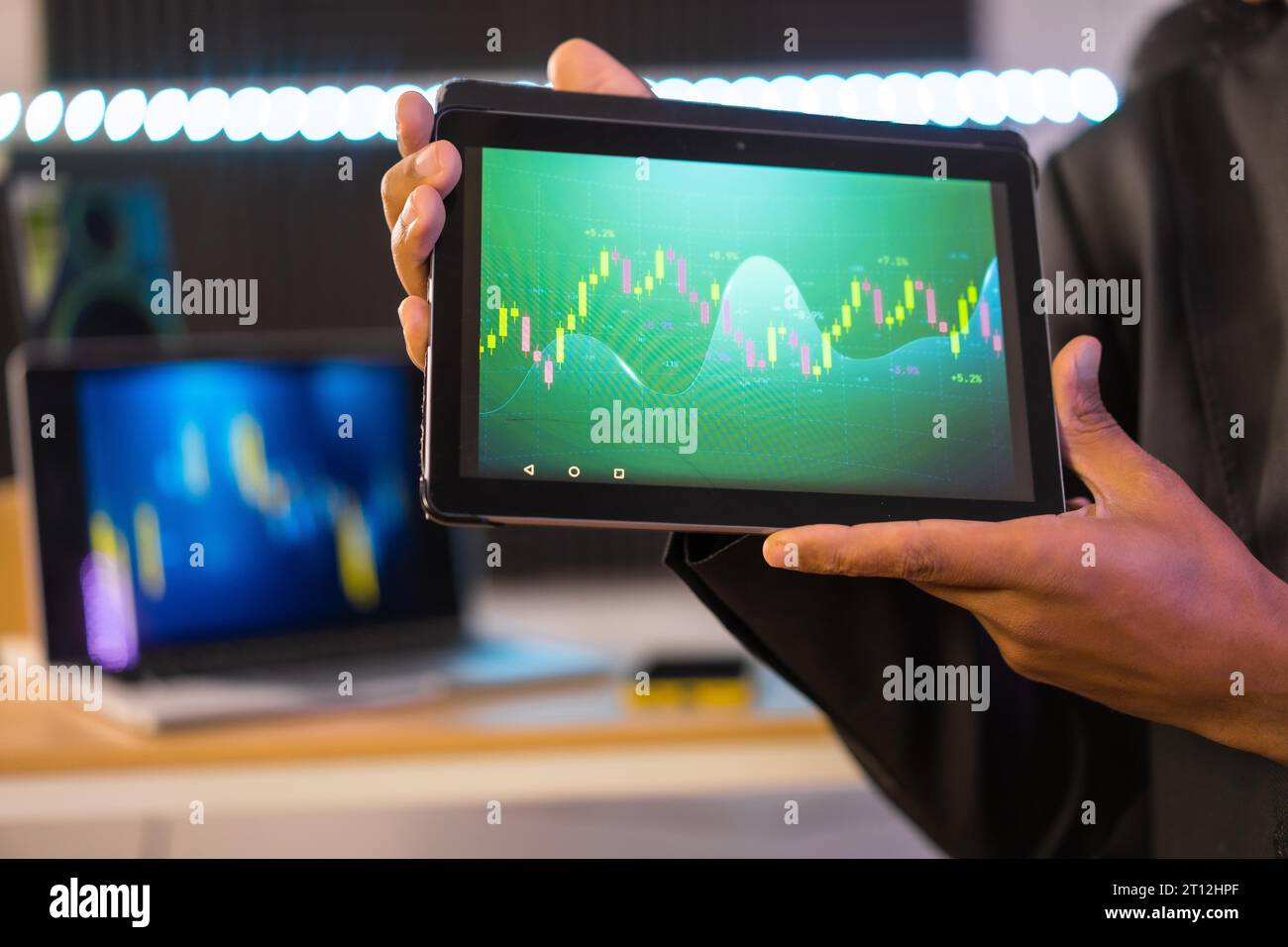 Horizontal close-up photo of the hands of a trader showing a screen ...