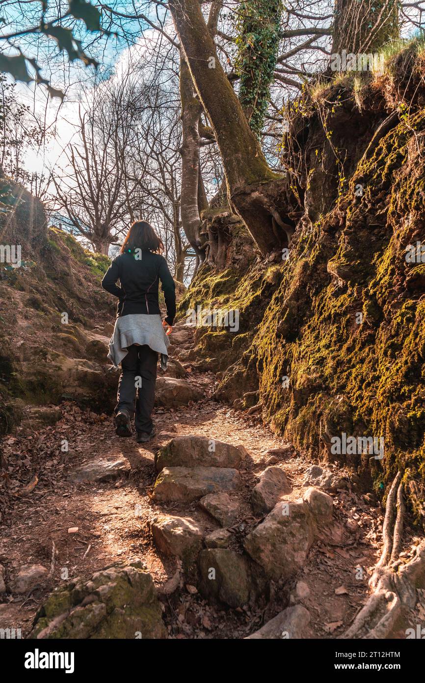 A young girl in black in the mud ramps of the trail of Mount Adarra in ...