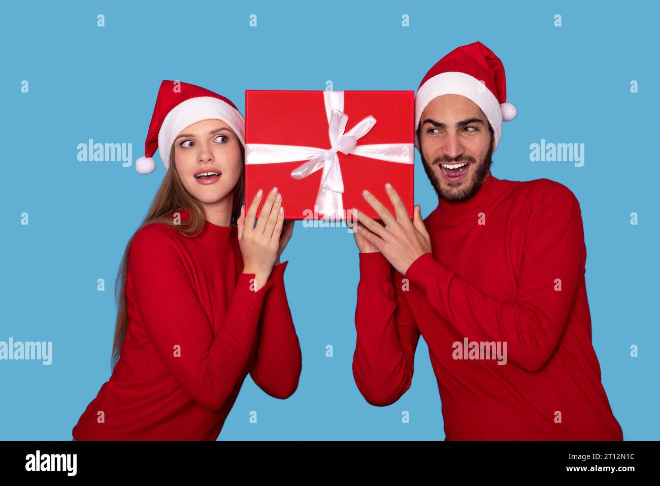 Surprise Gift. Excited Young Couple Shaking Wrapped Box With Christmas ...