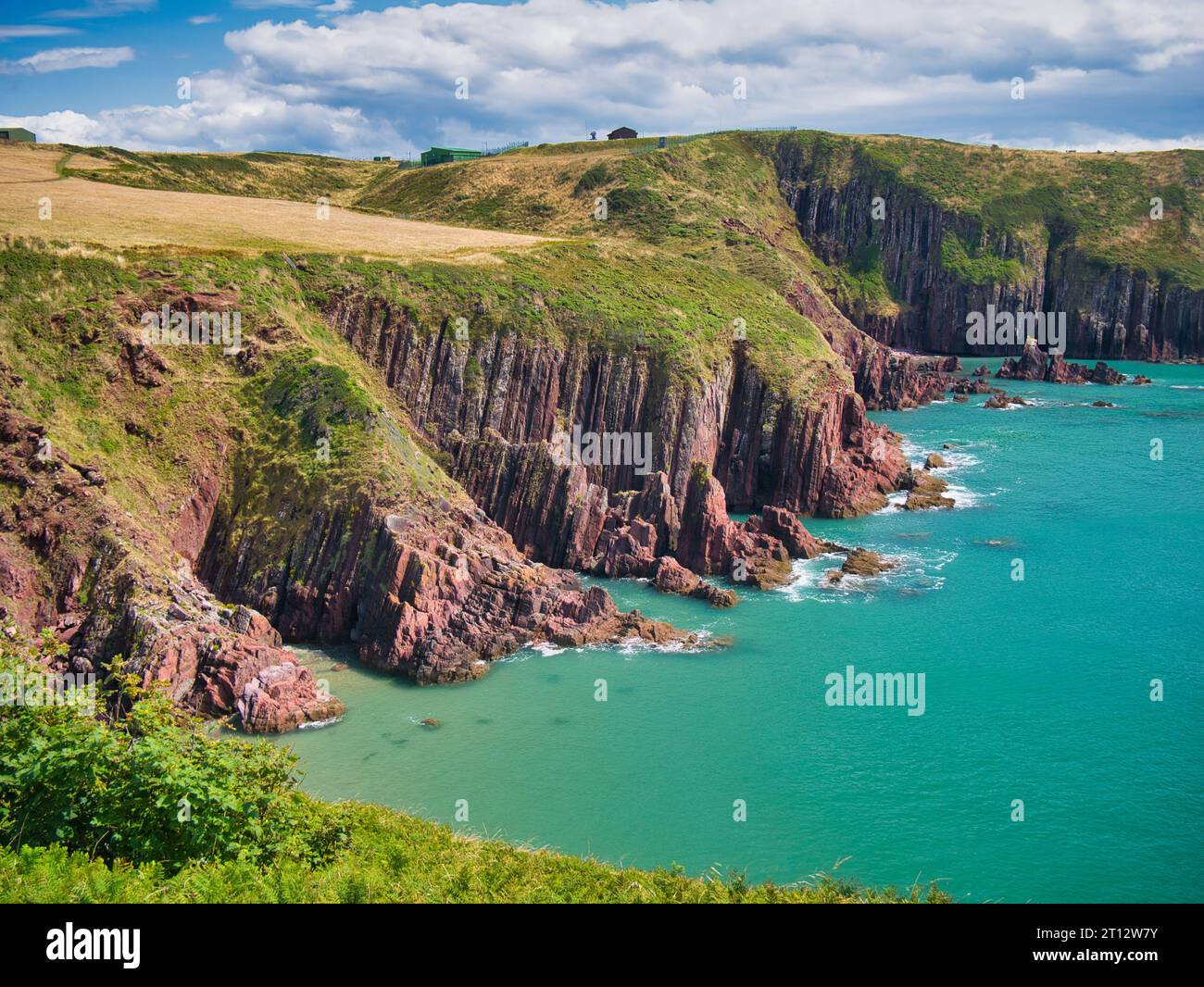 Coastal red cliffs near Manorbier in Pembrokeshire, Wales, UK - the ...