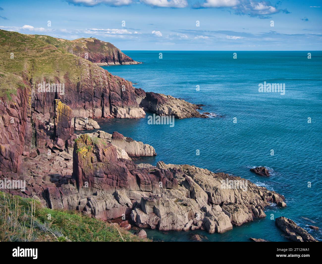 Coastal red cliffs near Manorbier in Pembrokeshire, Wales, UK - the ...
