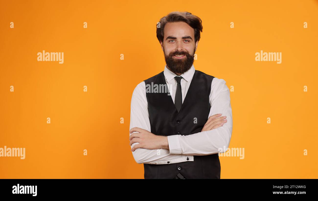 Fancy butler on yellow background studio, posing with confidence before ...