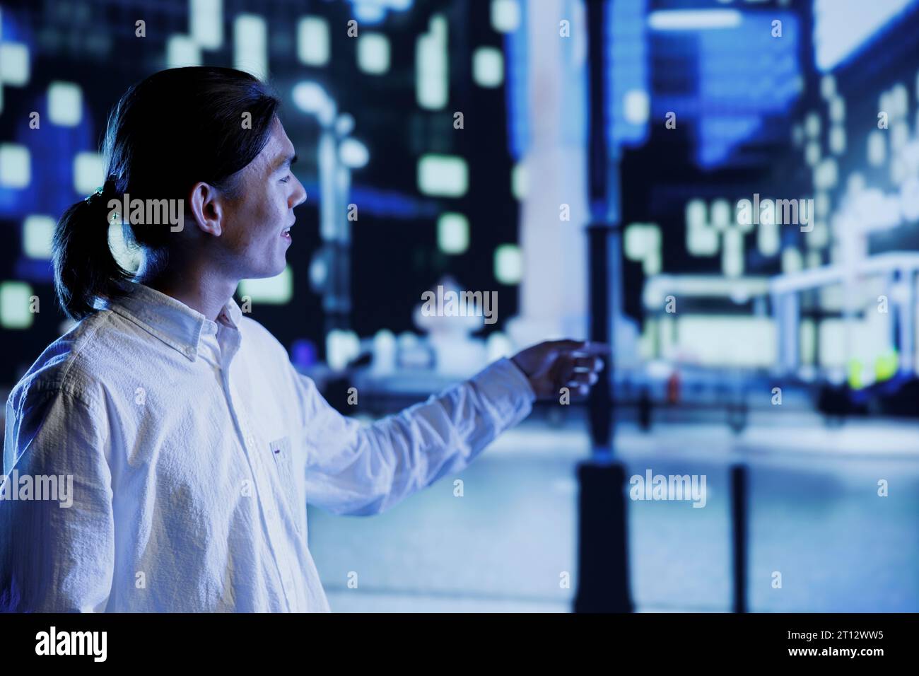 Relaxed asian man wandering around city streets at night, looking ...
