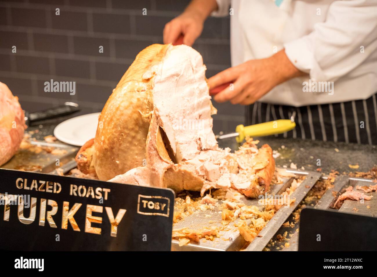 chef sliced roast turkey placed under heated serving counter to be ...