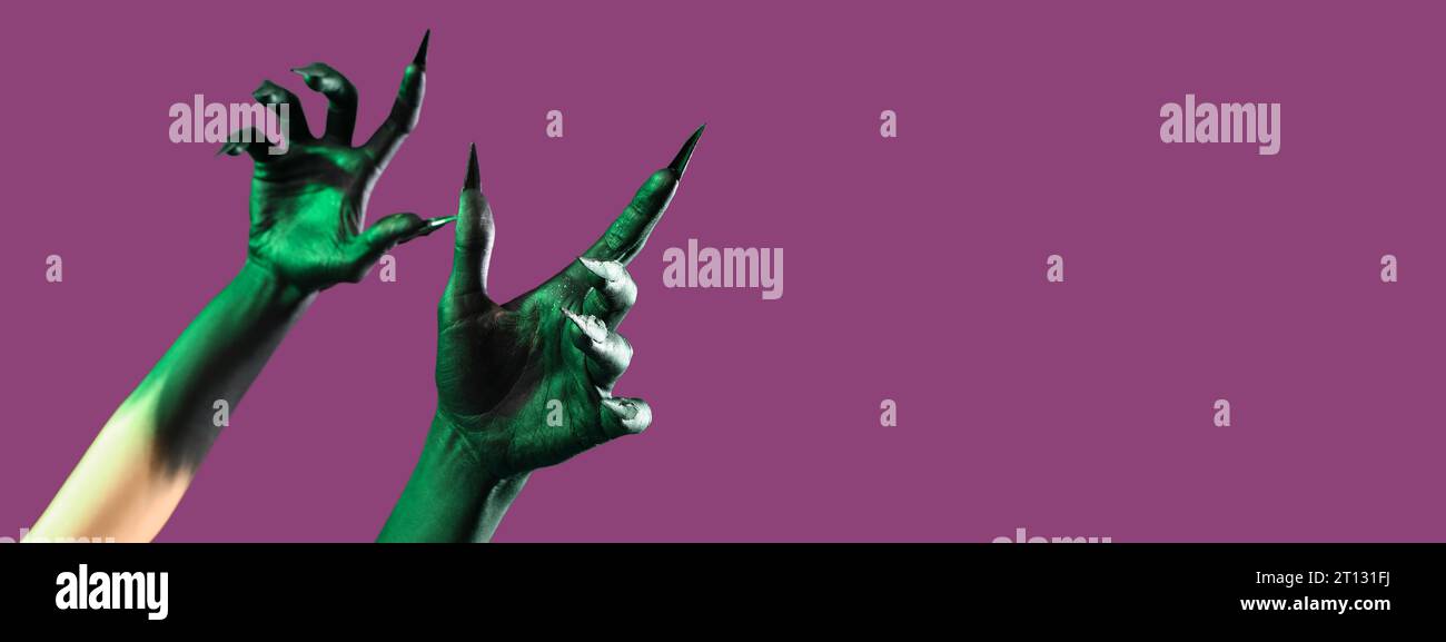 Green hands of witch with claws on purple background with space for ...