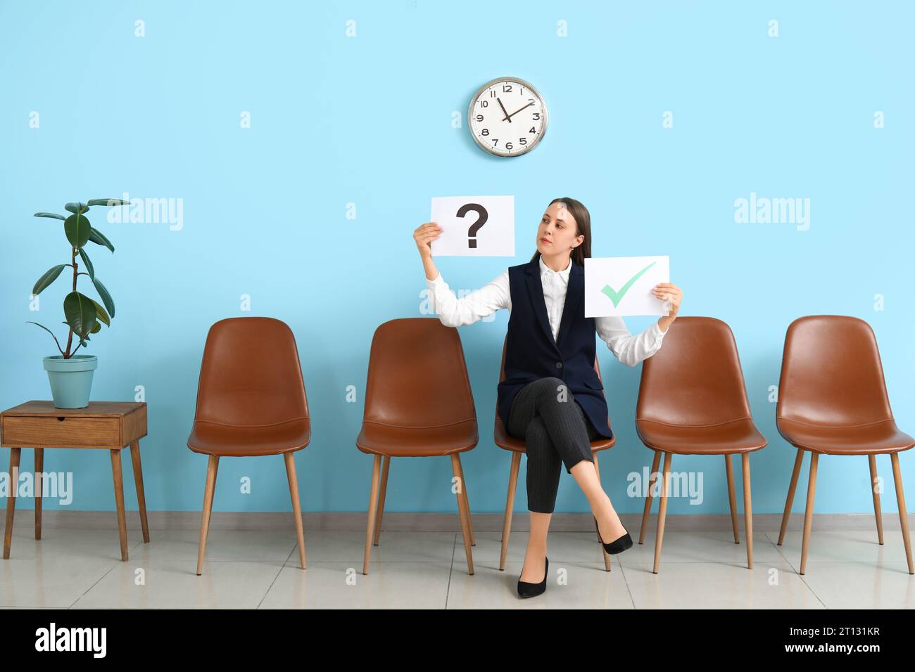 Female applicant holding paper sheets with question and check marks in ...