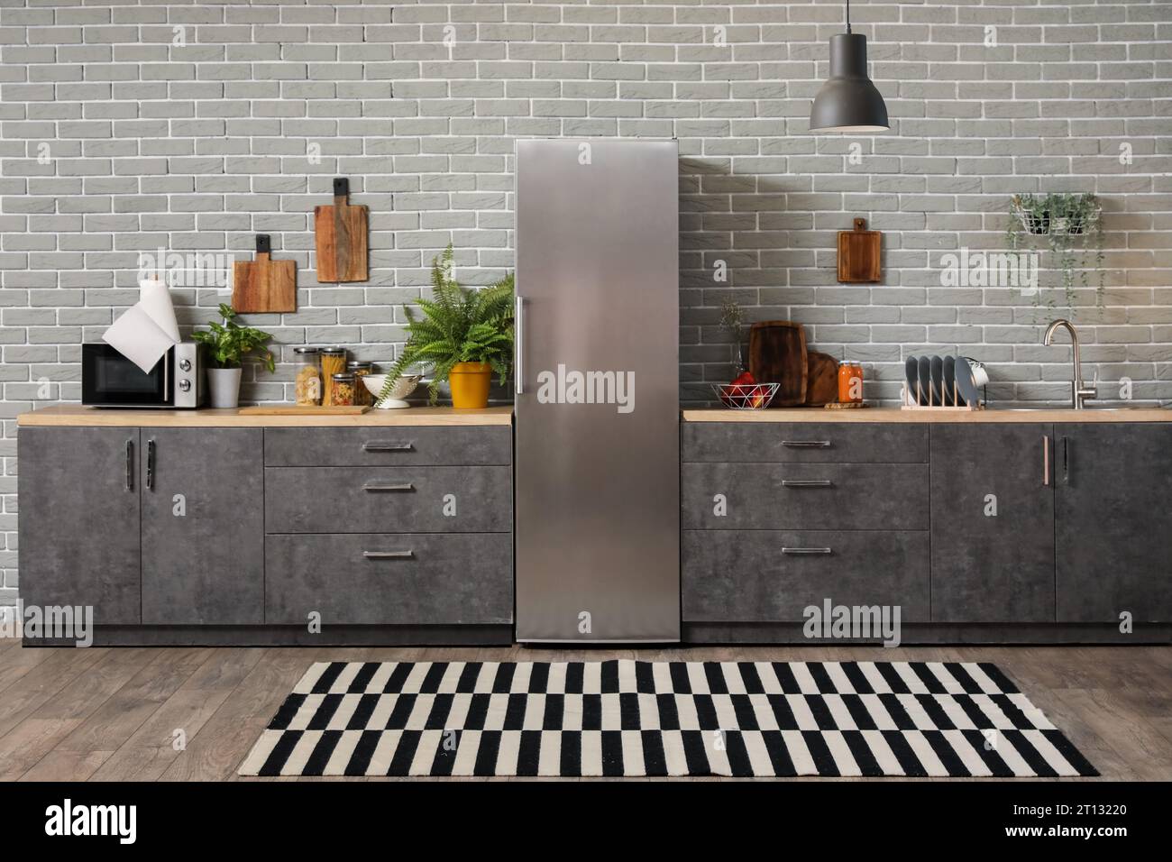 Interior of modern kitchen with grey counters, fridge and houseplants ...