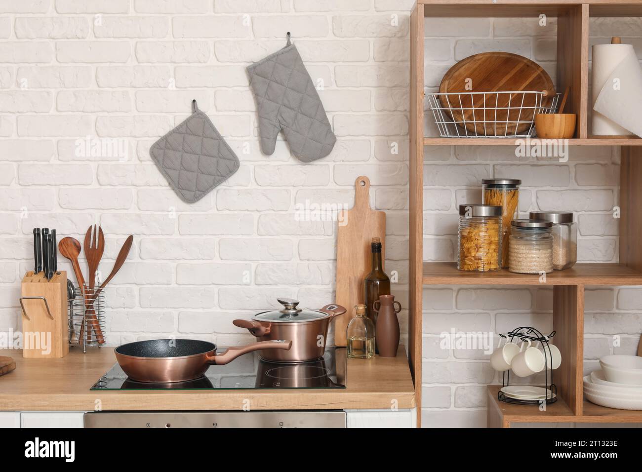 Wooden kitchen counter with cutting boards, electric stove and utensils ...