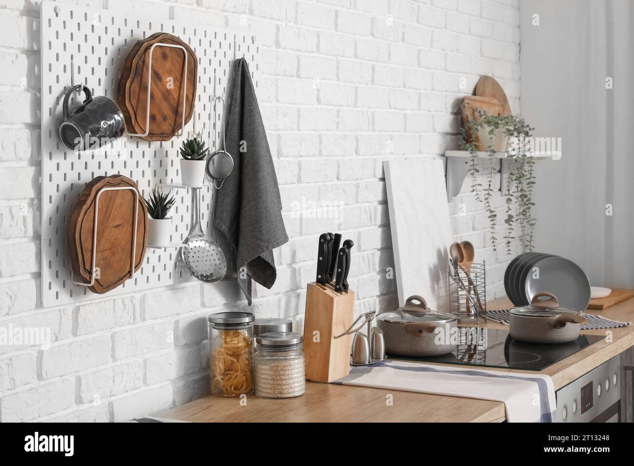 Pegboard with cutting boards and utensils on wooden counters in ...
