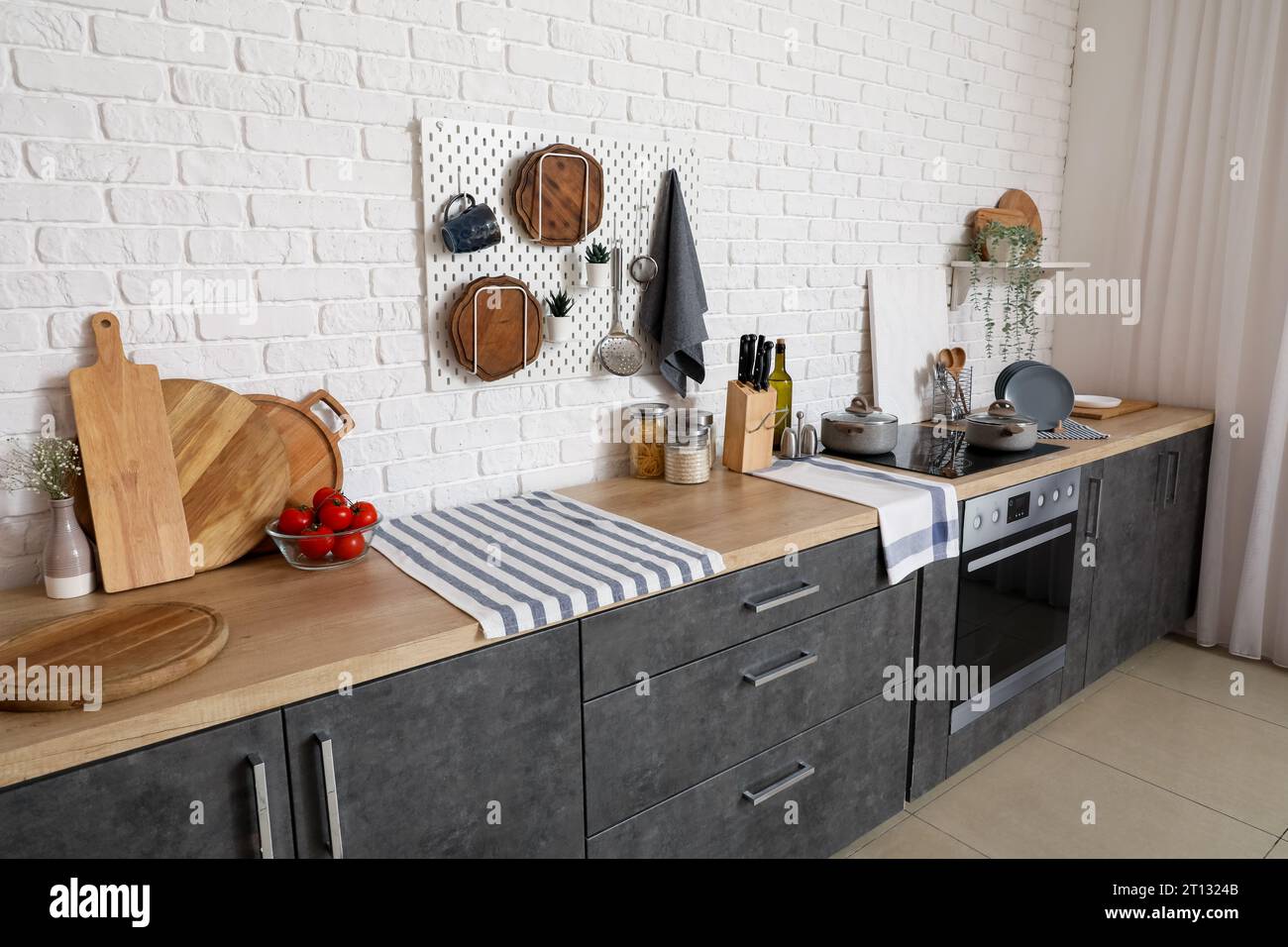 Interior of modern kitchen with cutting boards, pegboard, electric ...