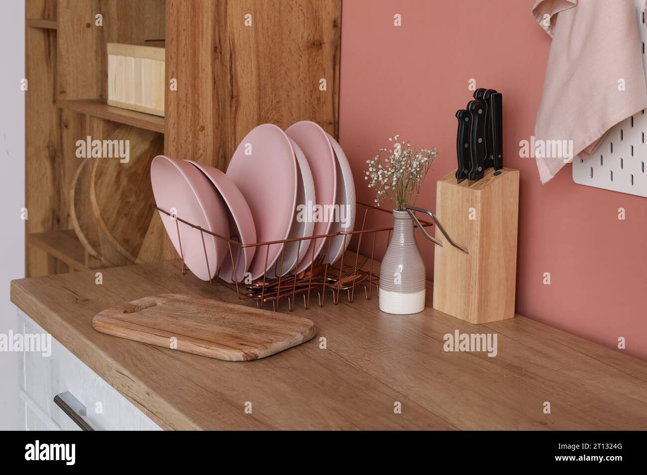 Wooden kitchen counter with plate rack, cutting boards and utensils ...