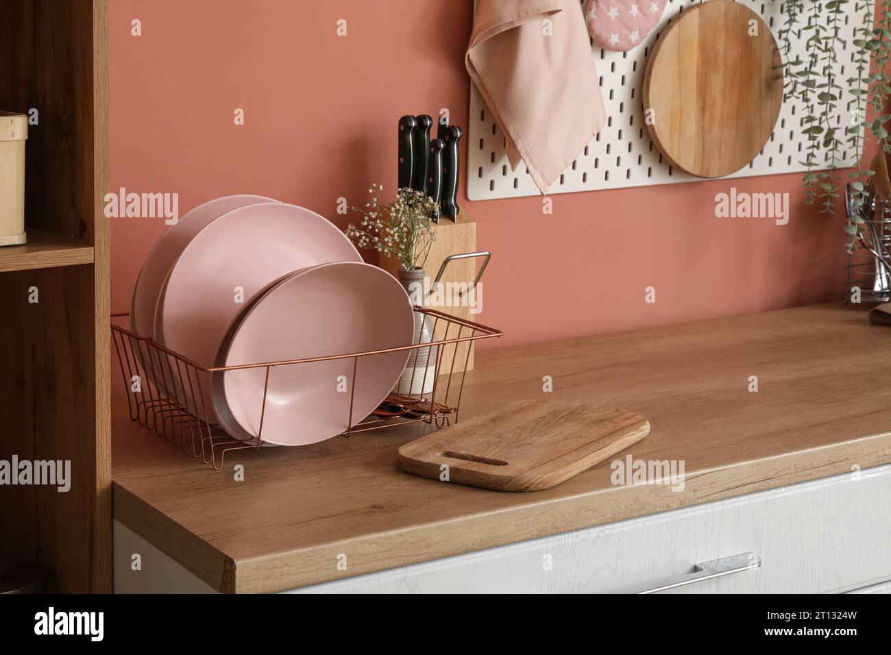Wooden kitchen counter with plate rack, cutting boards and utensils ...