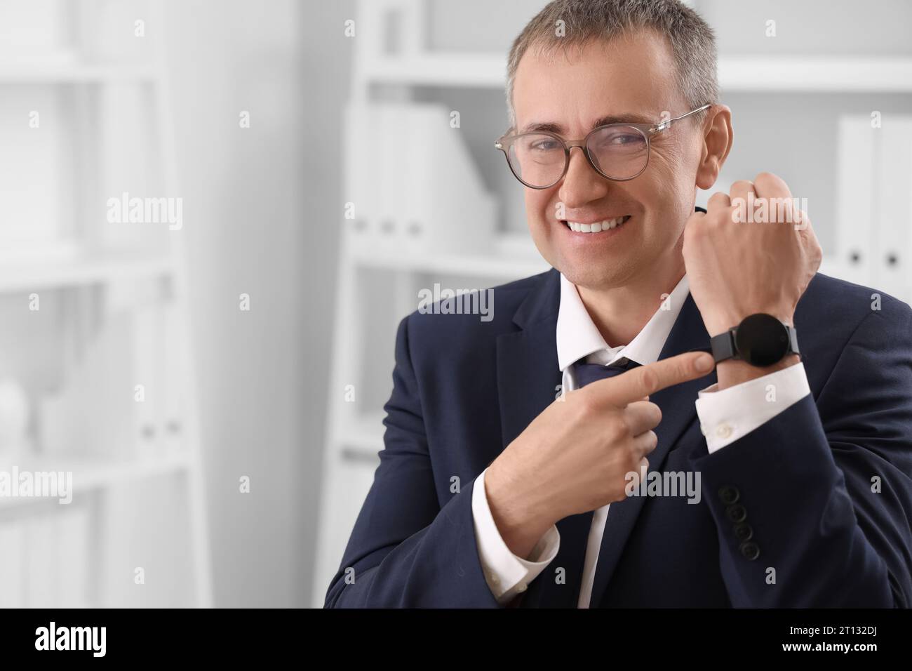 Mature businessman pointing at smartwatch in office, closeup Stock ...