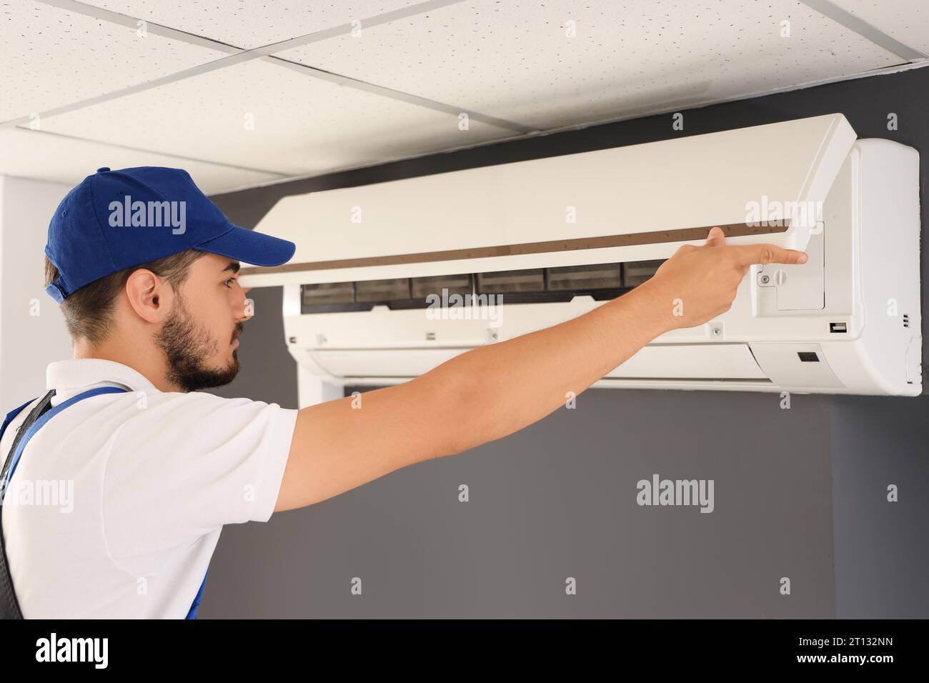 Male technician fixing air conditioner in room Stock Photo - Alamy