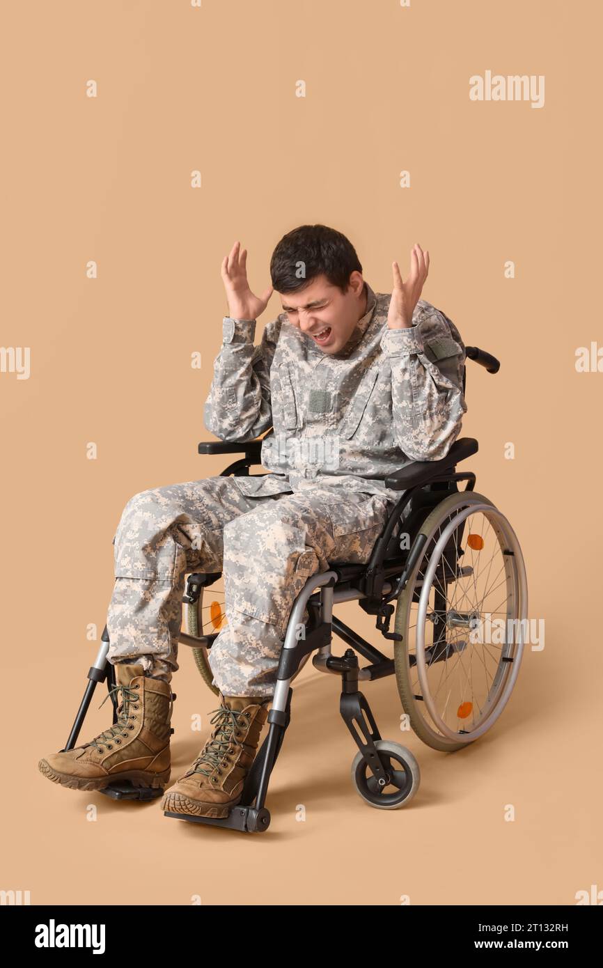 Young soldier in wheelchair screaming on beige background Stock Photo ...