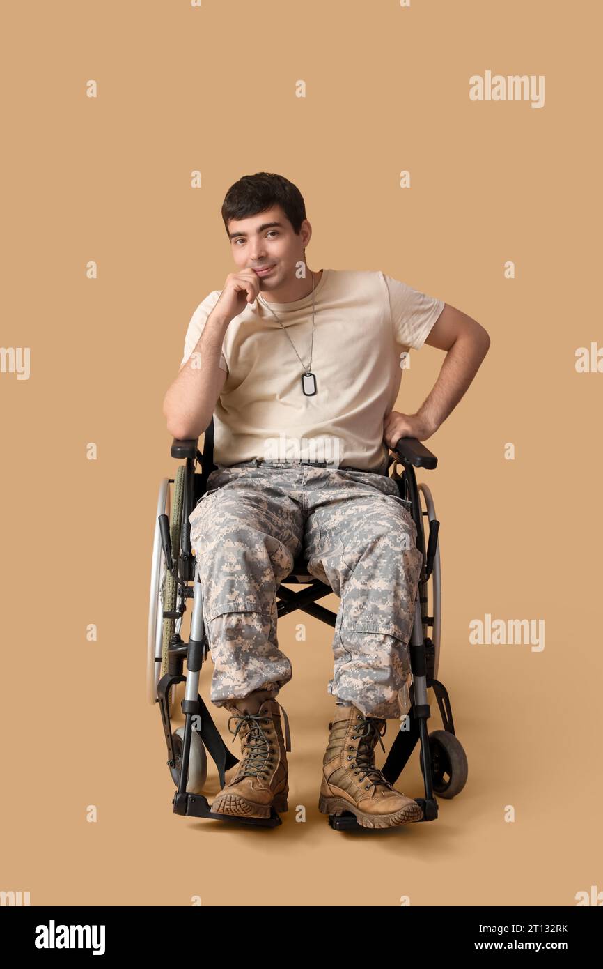 Thoughtful young soldier in wheelchair on beige background Stock Photo ...
