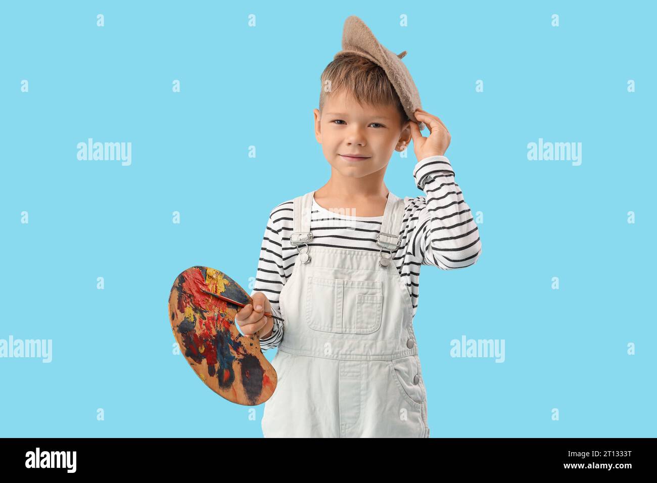 Cute little artist with paint palette on blue background Stock Photo ...