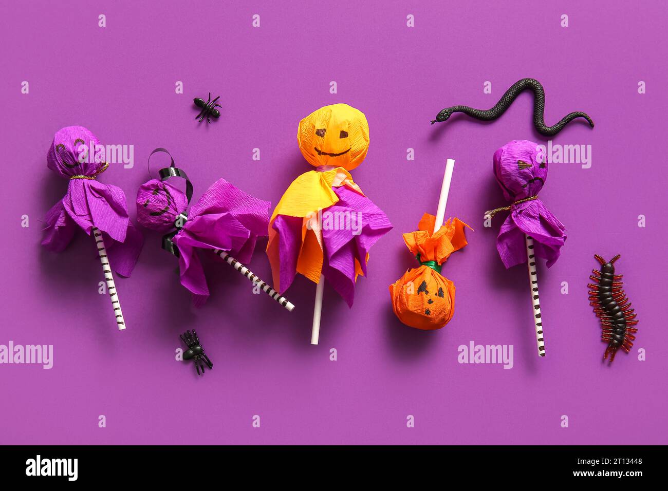 Sweet lollipops and candy bugs for Halloween party on purple background ...