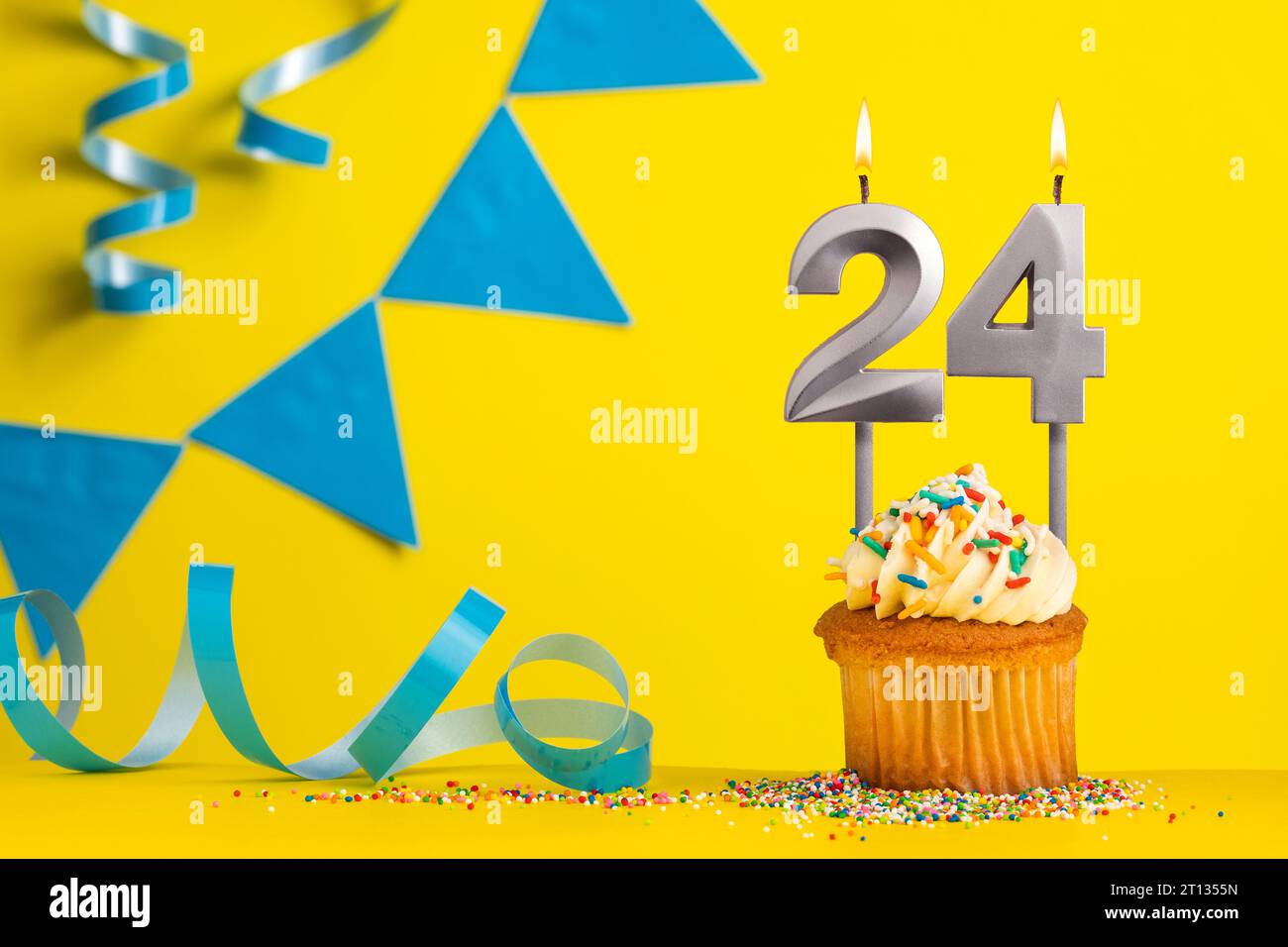 Lighted birthday candle number 24 - Yellow background with blue ...