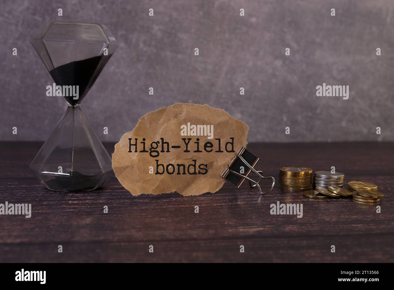 high yield bonds text on torn paper on wooden background near white ...