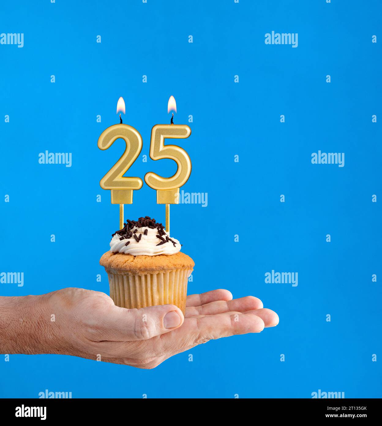 Hand delivering birthday cupcake - Candle number 25 on blue background ...