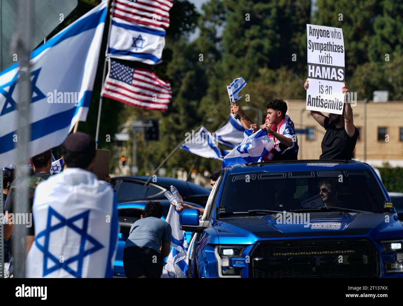 Supporters carrying signs and Israeli flags join in a pro-Israel rally ...