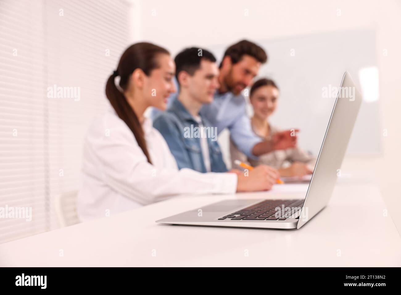 Teacher giving lesson in driving school, focus on laptop on white desk ...