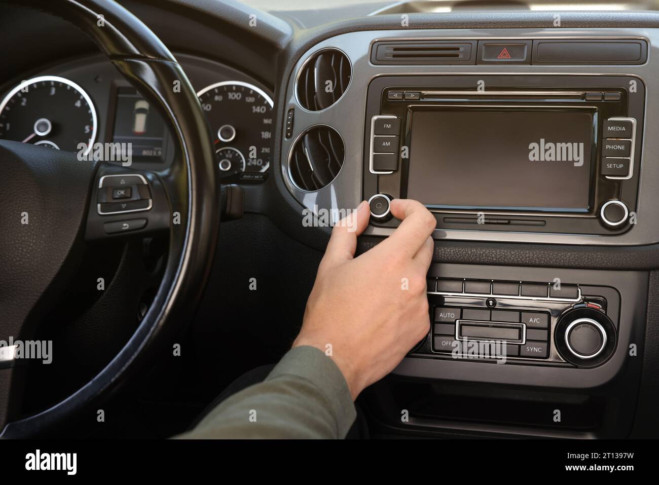 Listening to radio while driving. Man turning volume button on vehicle ...
