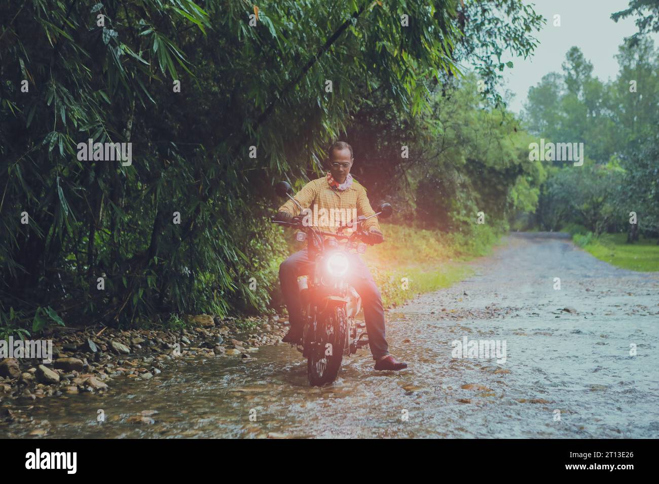 asian man riding small enduro motorcycle crossing flowing creek in ...