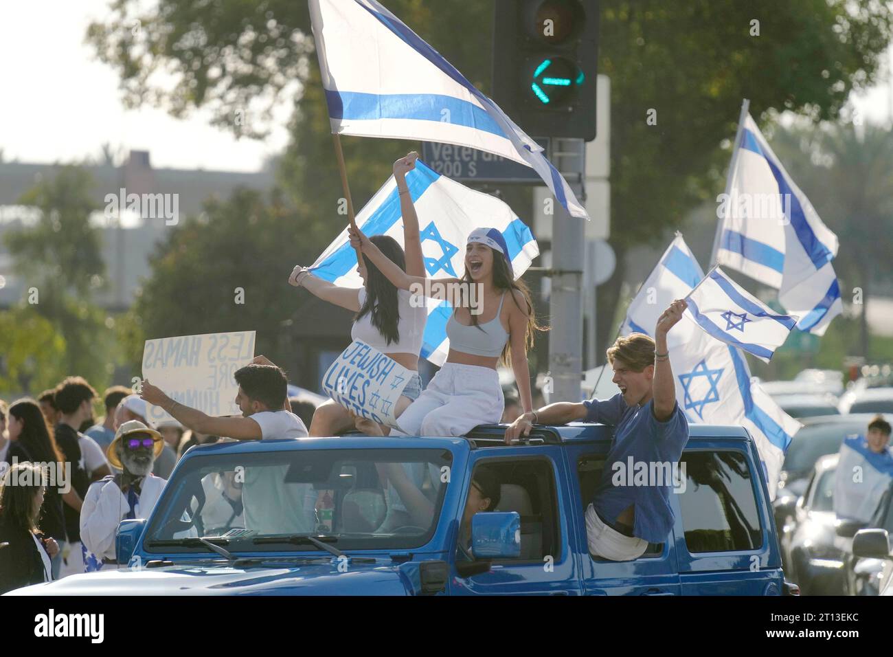 Supporters wave Israeli flags from passing vehicles during a pro-Israel ...