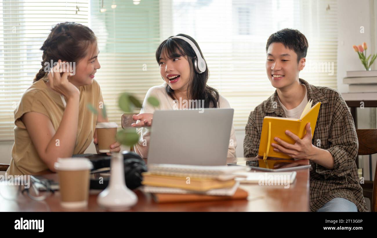 A group of cheerful young Asian college students are enjoying talking ...