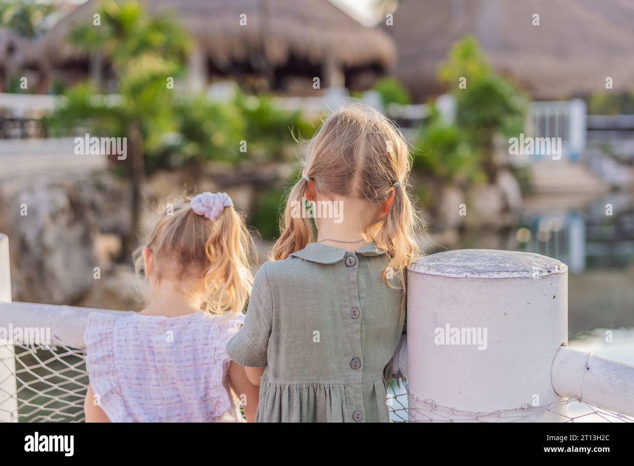 Two little girls take a delightful stroll along the yacht marina, their ...