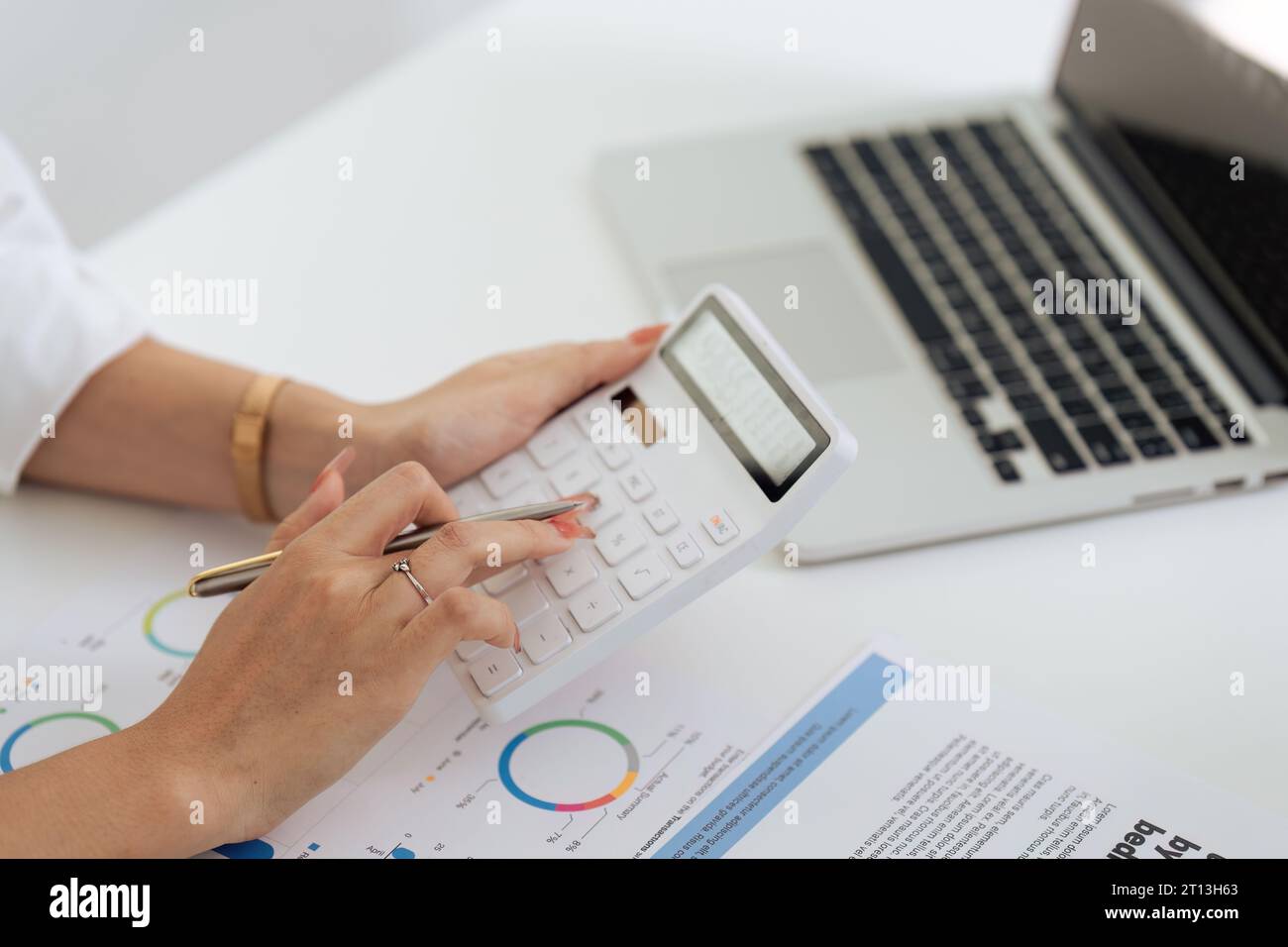 Businesswoman using a calculator to calculate numbers on a company's ...