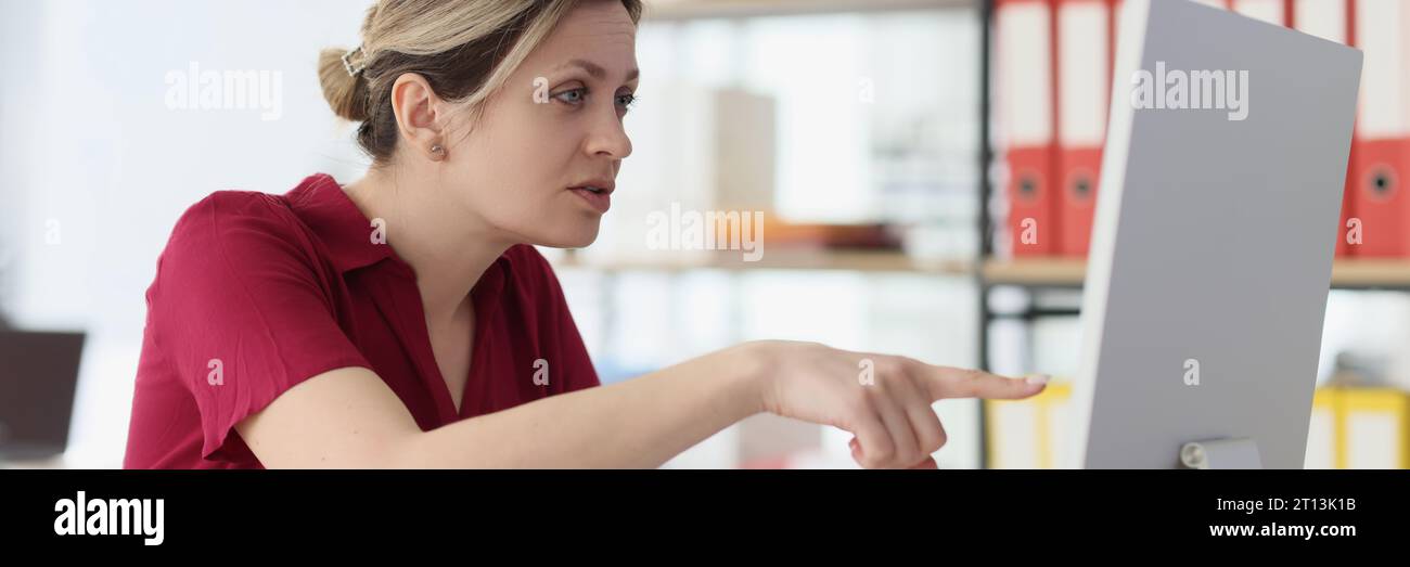 Suspicious woman points finger to screen of computer monitor Stock ...