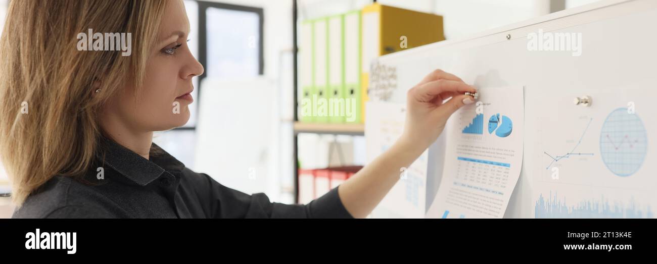 Manager pins paper with infographic charts on whiteboard Stock Photo ...
