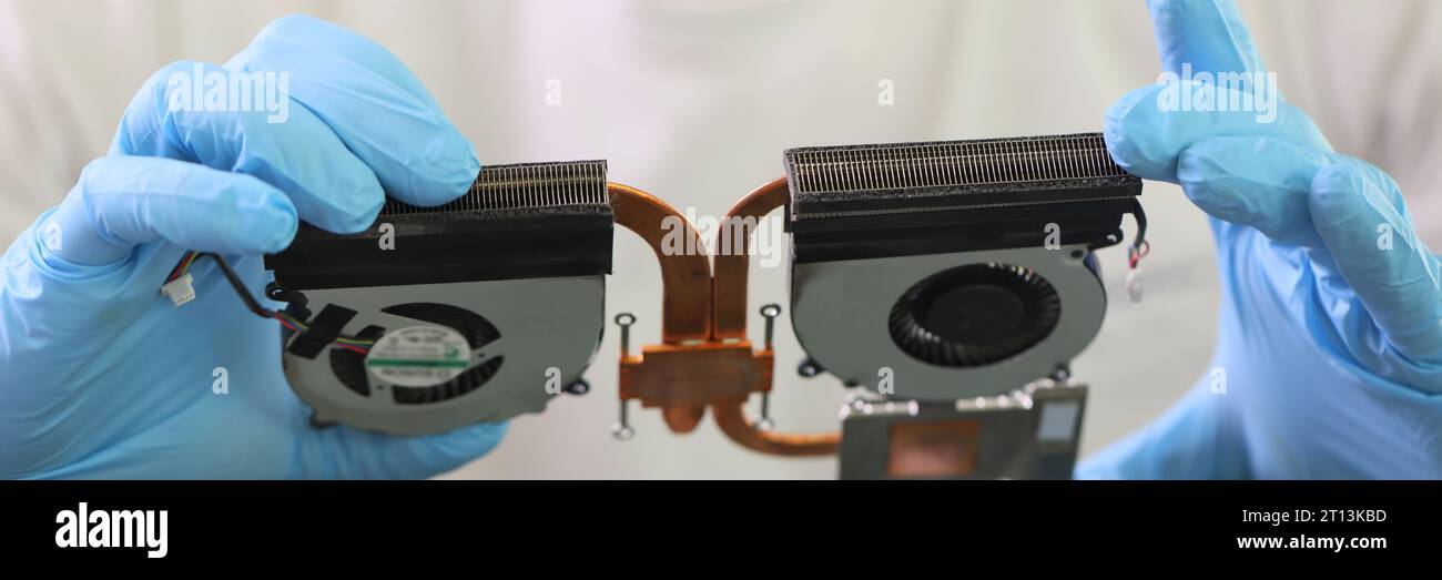 Master in rubber gloves holds cooling system of old laptop Stock Photo ...