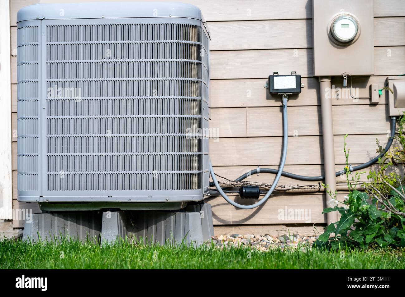 Outdoor residential air conditioner on an elevated pad. Electrical ...