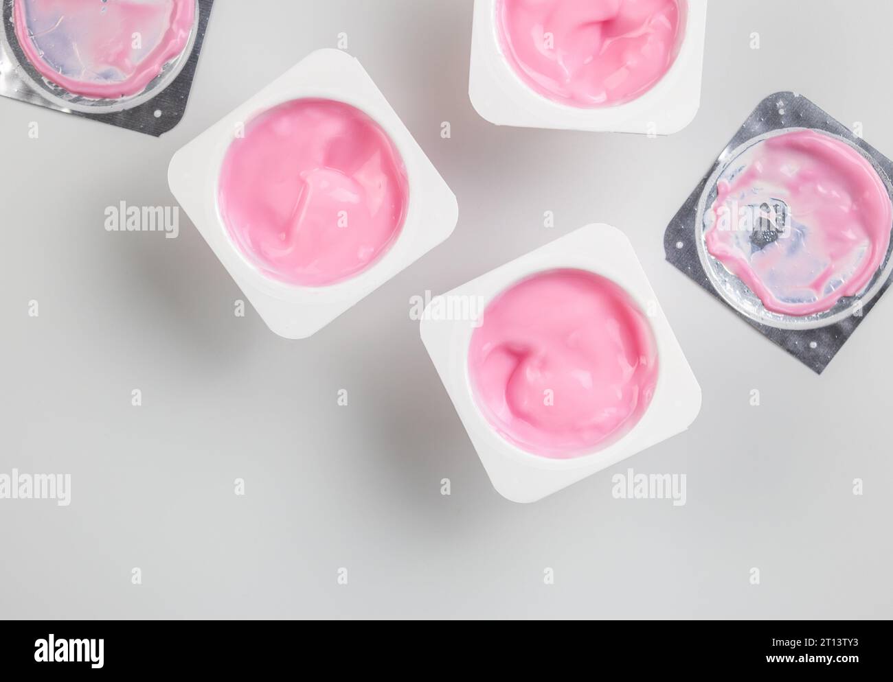 Pink yogurt cup - top view of strawberry yoghurt in plastic cups with ...
