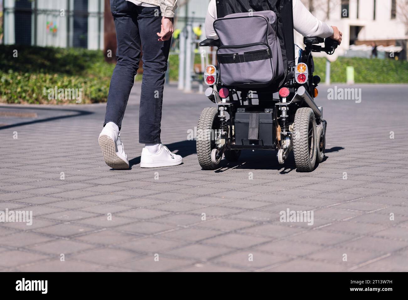man walking with a person using wheelchair Stock Photo - Alamy