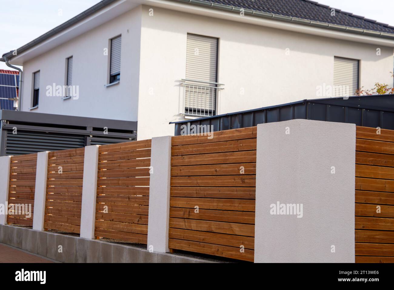 Concrete fence with wooden elements as privacy screen on a residential ...
