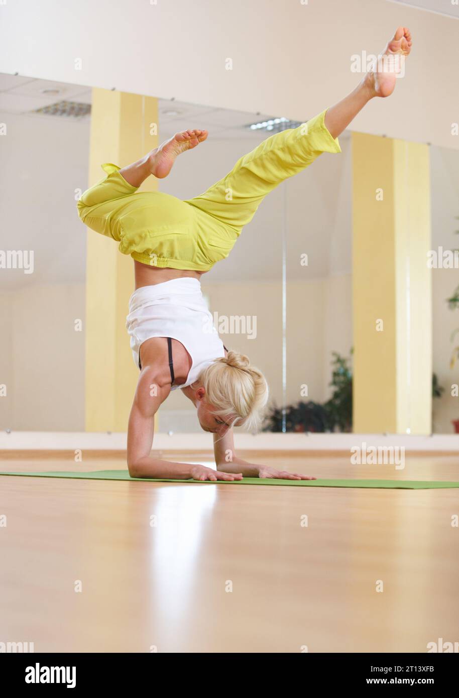 Beautiful sporty fit yogi woman practices yoga asana Vrischikasana ...