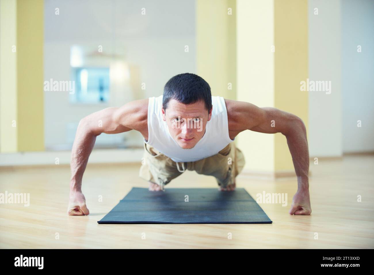 A young strong man doing yoga exercises - Chaturanga Dandasana four ...