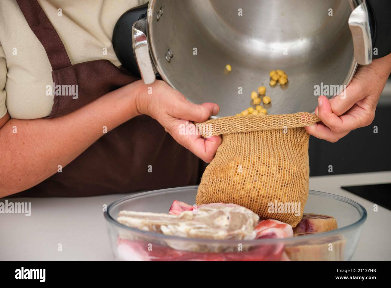 Mature Spanish woman cooking cocido madrileño, typical Spanish dish ...