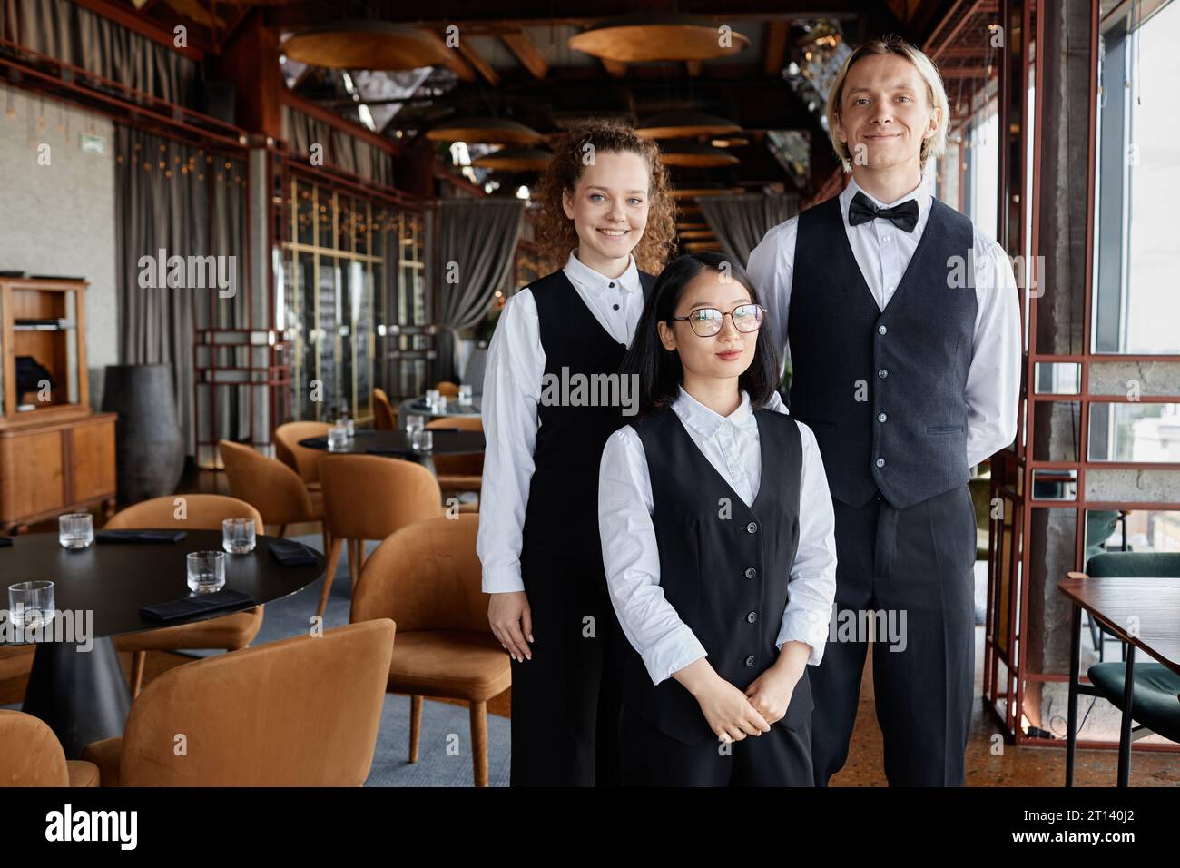 Front view portrait of three servers wearing classic uniform in luxury ...